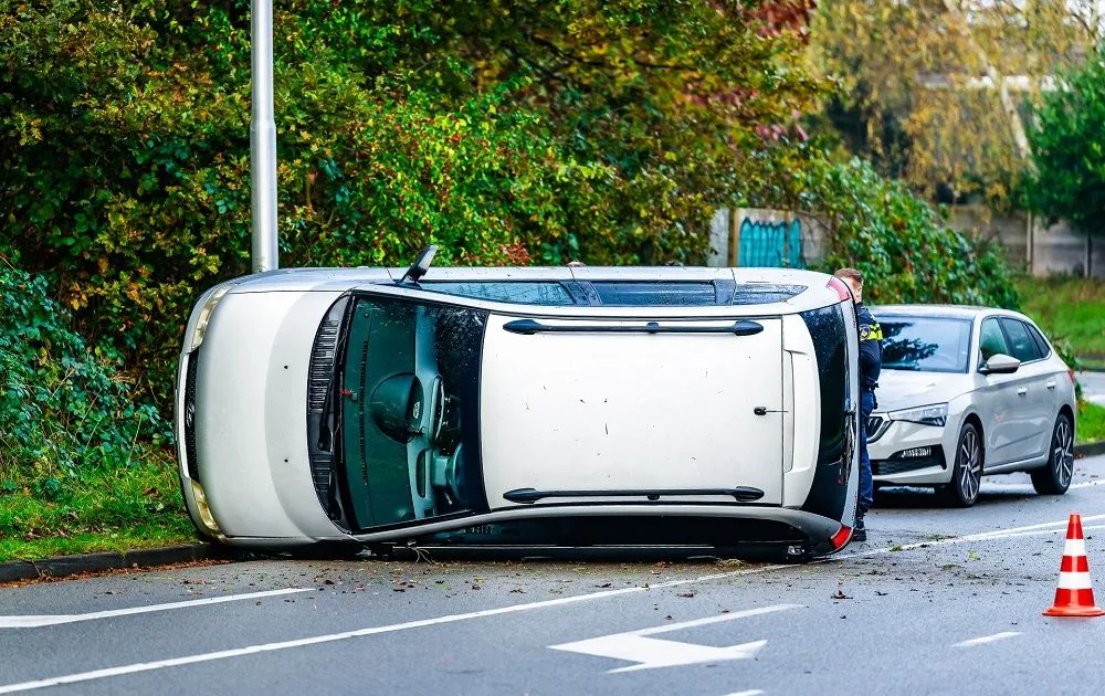 Auto op zijkant na aanrijding op Huibevendreef