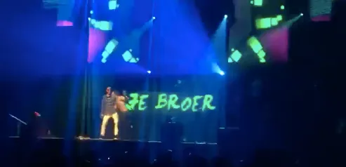 Rapper Jebroer slaat een jongen van het podium af.