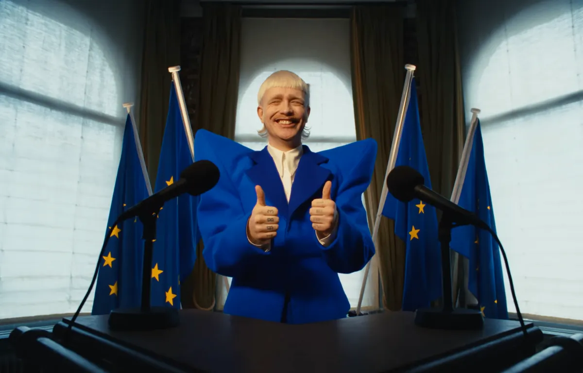 Appie Musa in een blauw vogelpak, kleurige beelden en hakken in eerste ...
