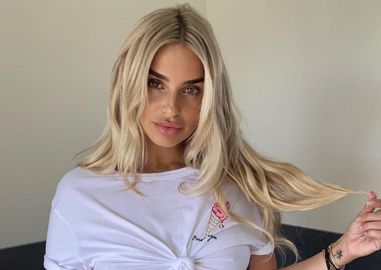 Hollandse bom Gaby Blaaser flaneert schaars gekleed achter de ...