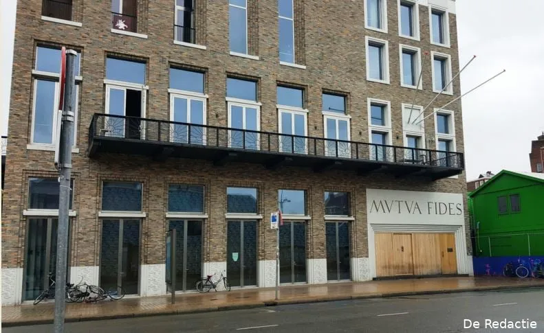 Persoon rent van dak Vindicat gebouw af